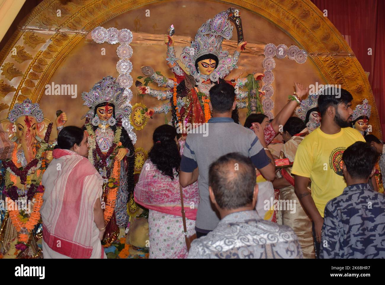Long shot of Bengali devotees offering sweets to goddess Durga and ...