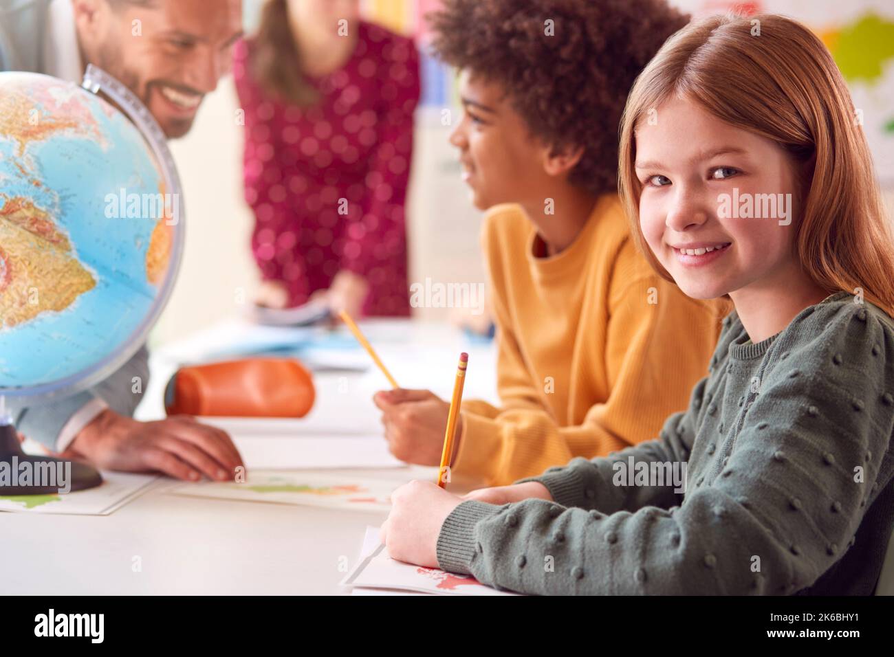Group Of Multi-Cultural Students With Teachers In Classroom Looking At ...