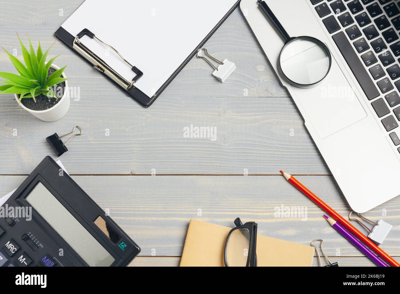 Top view of wooden desktop with glasses and stationery items close up ...