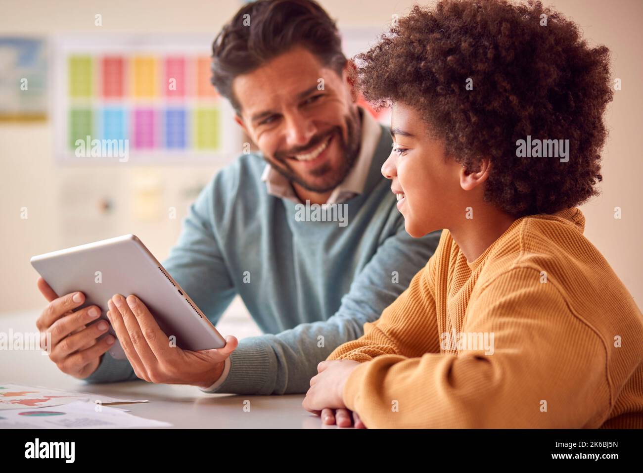 Teacher And Male Student In School Classroom Using Digital Tablet ...