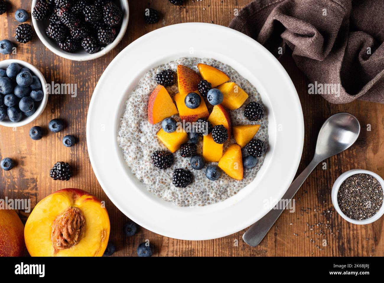 Chia pudding bowl with peach and blueberries on wooden table background ...