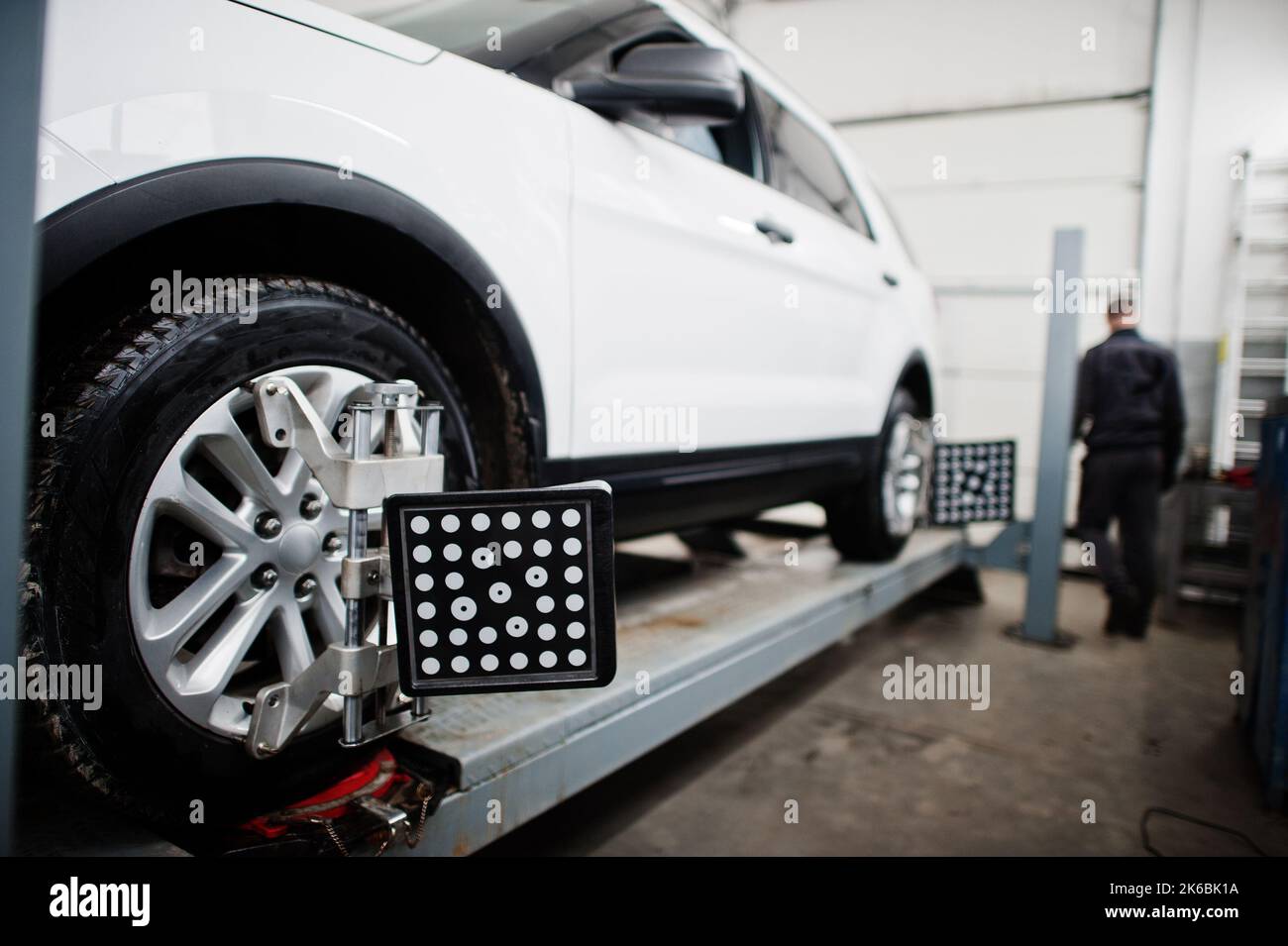 American SUV car on stand for wheels alignment camber check in workshop ...