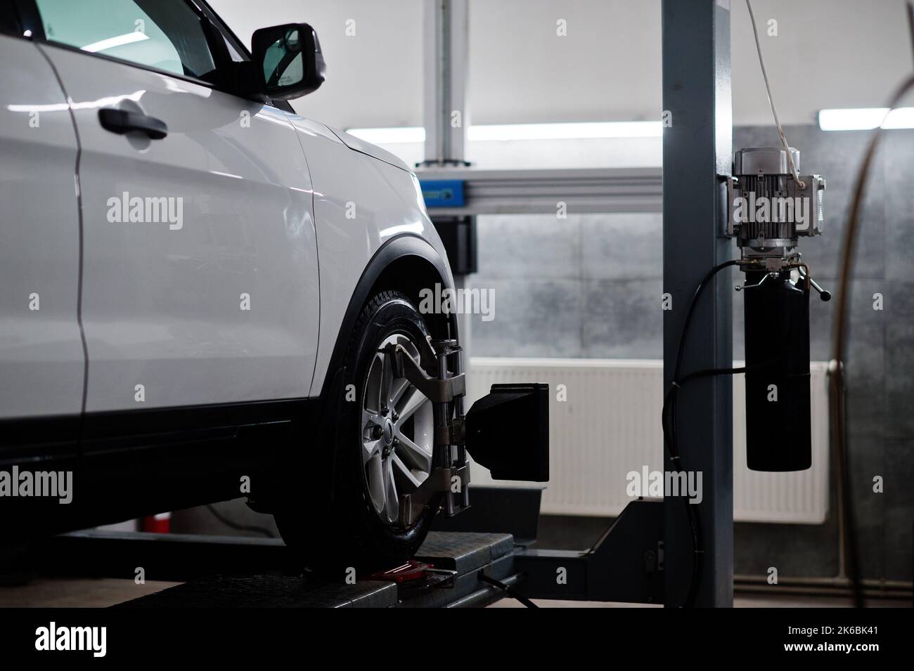American SUV car on stand for wheels alignment camber check in workshop ...