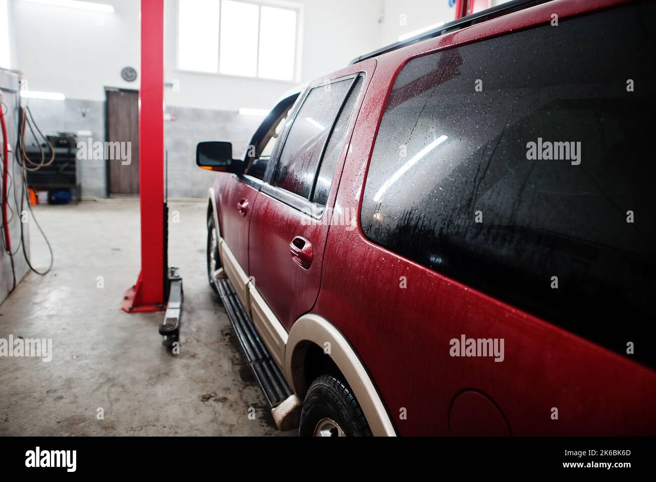 American SUV car on stand for wheels alignment camber check in workshop ...