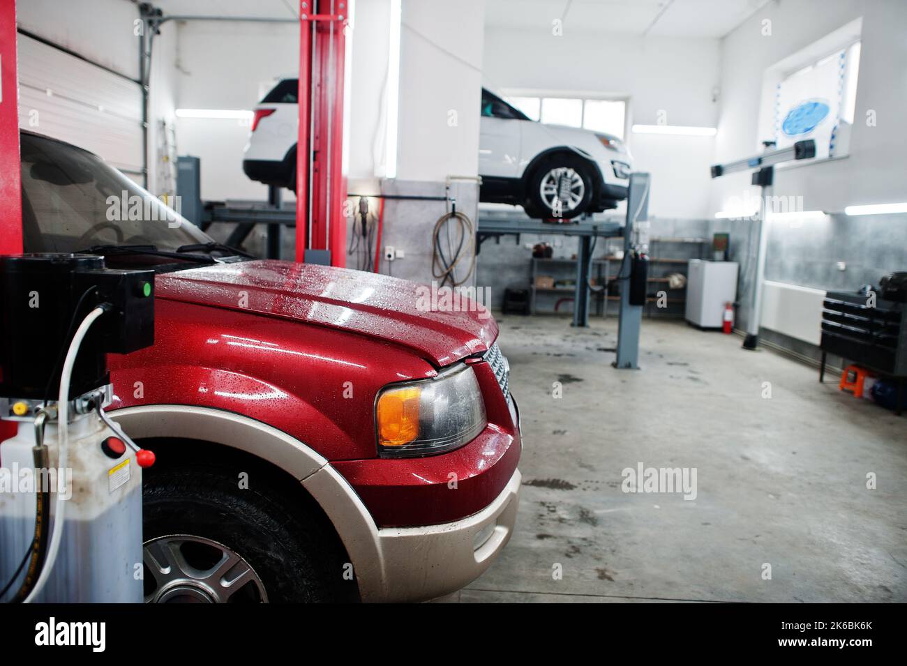 Two american SUV car on stand for wheels alignment camber check in ...