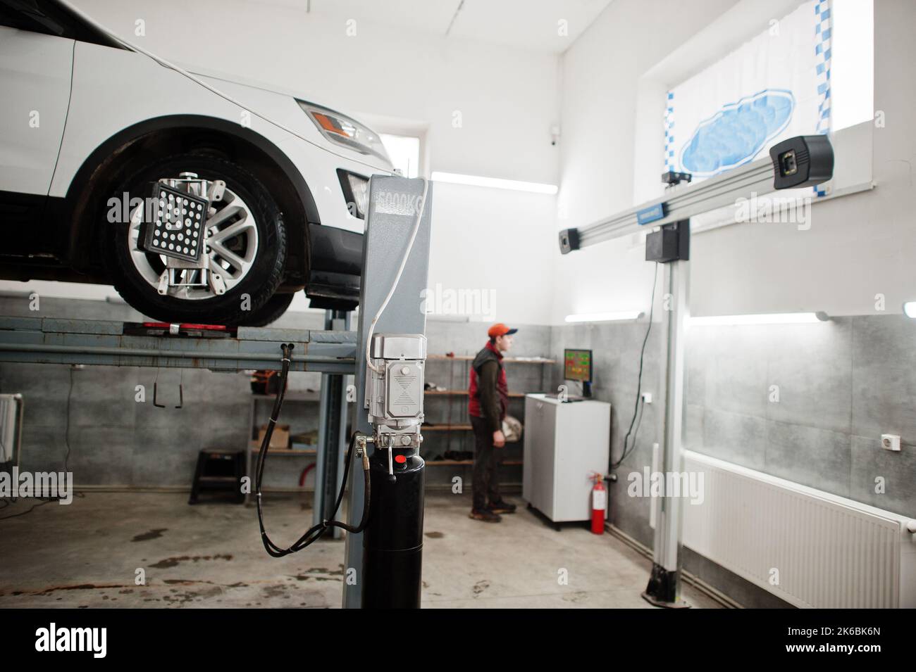 American SUV car on stand for wheels alignment camber check in workshop ...