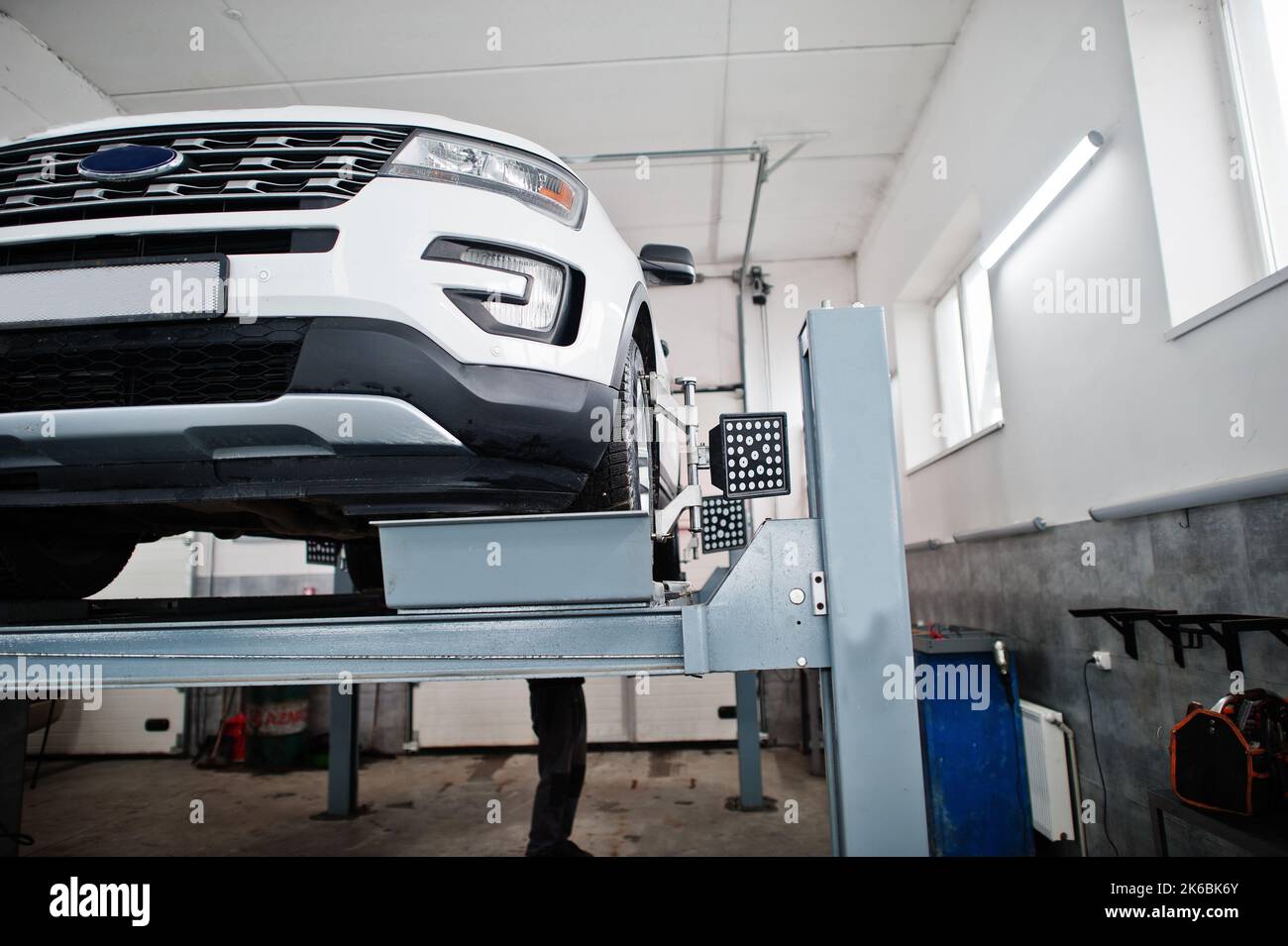American SUV car on stand for wheels alignment camber check in workshop ...