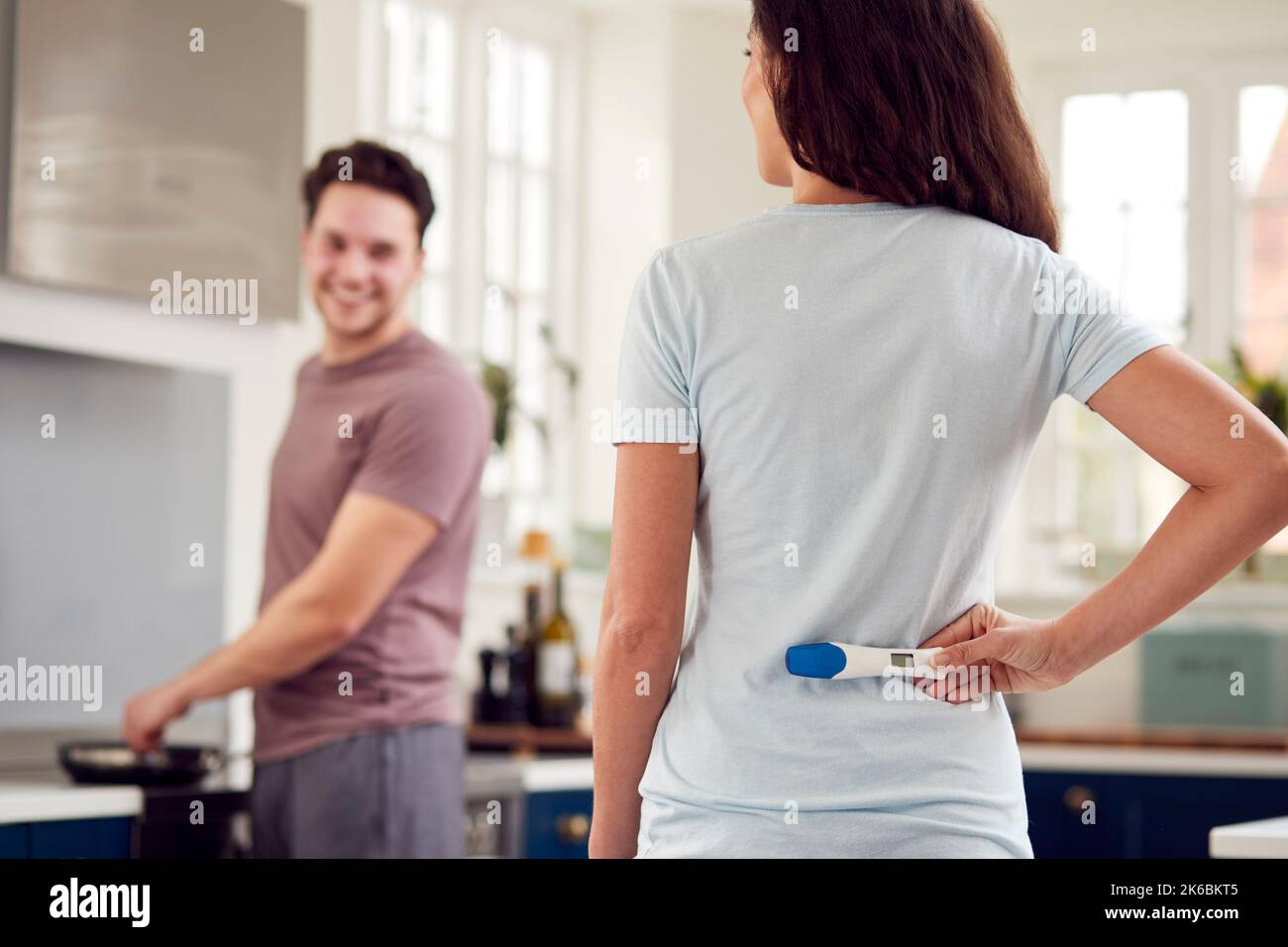 Transgender Couple At Home In Kitchen With Woman Surprising Man With ...