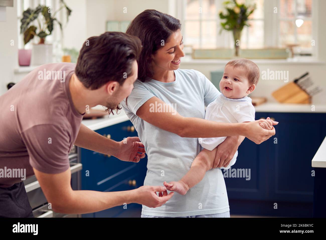 Loving Transgender Family With Baby In Kitchen At Home Together Stock ...