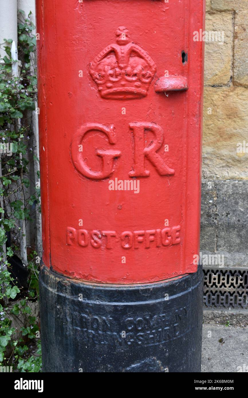 close up red painted British Royal Mail letter box outside in a street ...