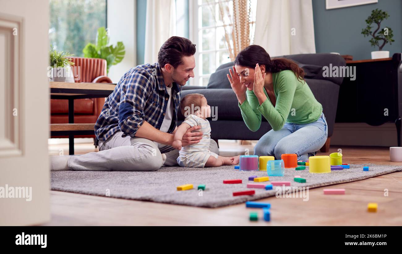 Transgender Family With Baby Playing Game With Colourful Toys In Lounge ...