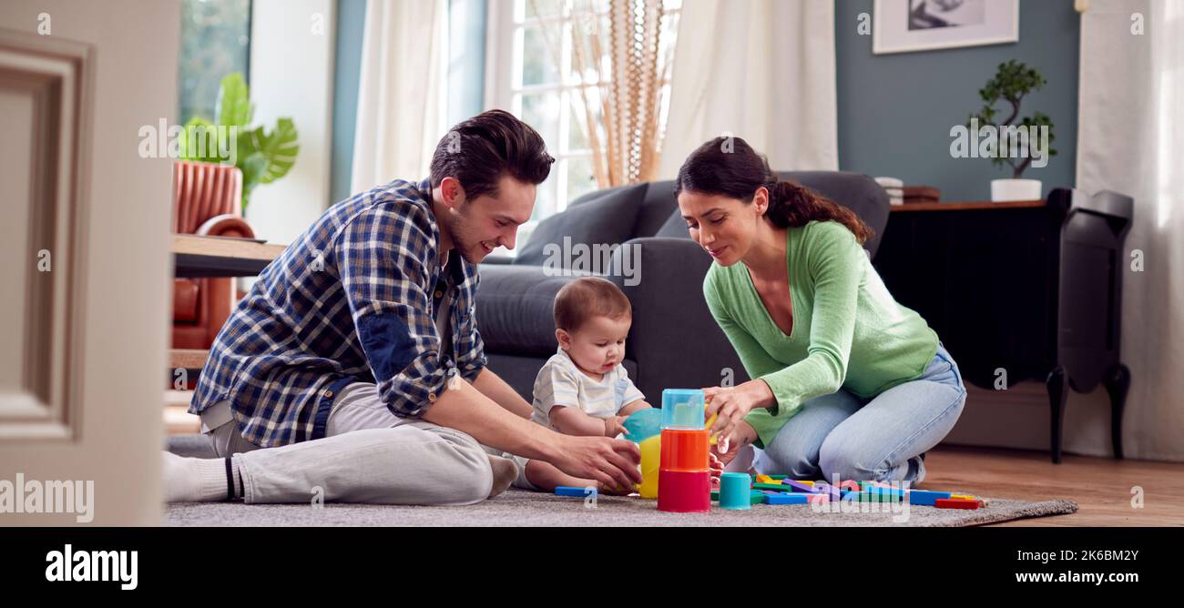 Transgender Family With Baby Playing Game With Colourful Toys In Lounge ...