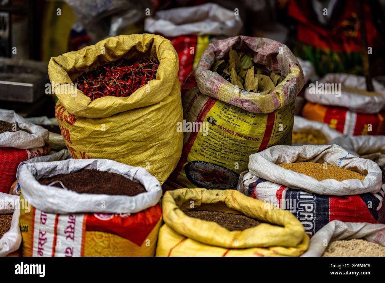A closeup of various beans, spices, vegetables sold at a market in ...