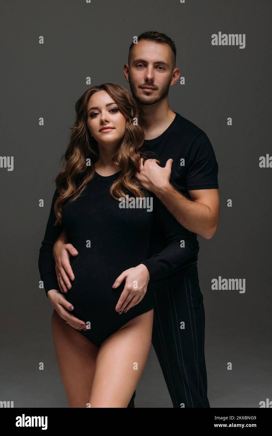 Pregnant Couple on black background Stock Photo - Alamy
