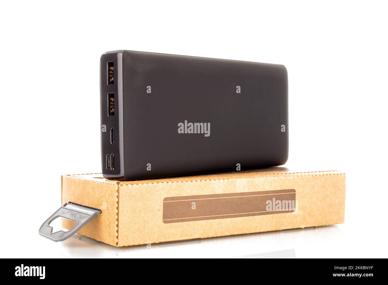 One new black portable battery on a paper package, macro, isolated on ...