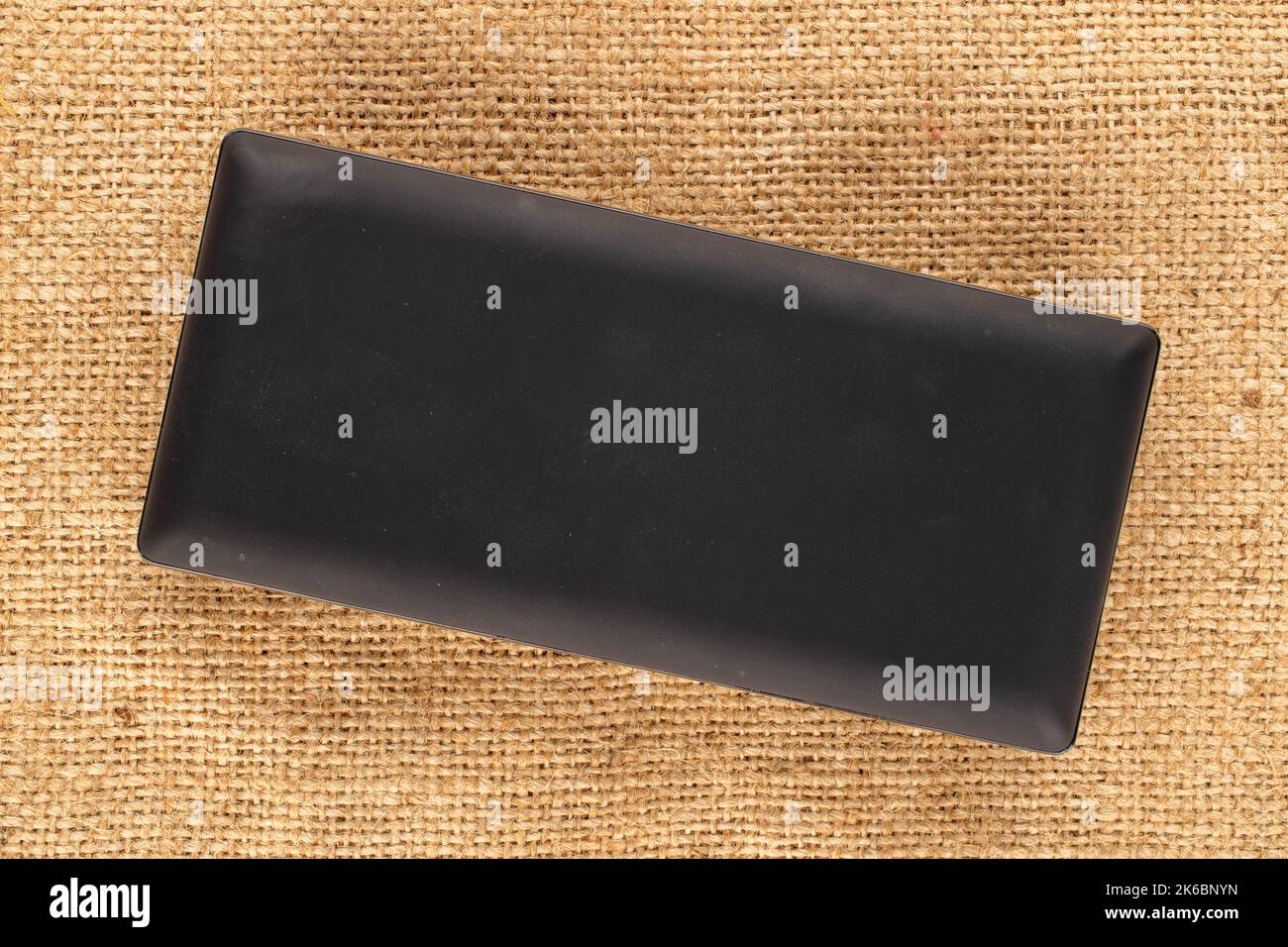 One new black portable battery on jute cloth, macro, top view Stock ...