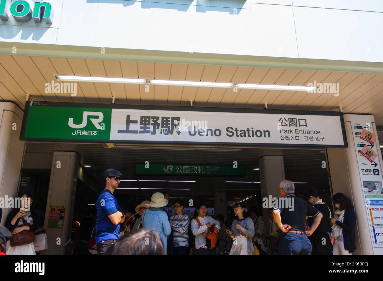 View of JR Ueno station Park entrance with signage and crowd of people ...