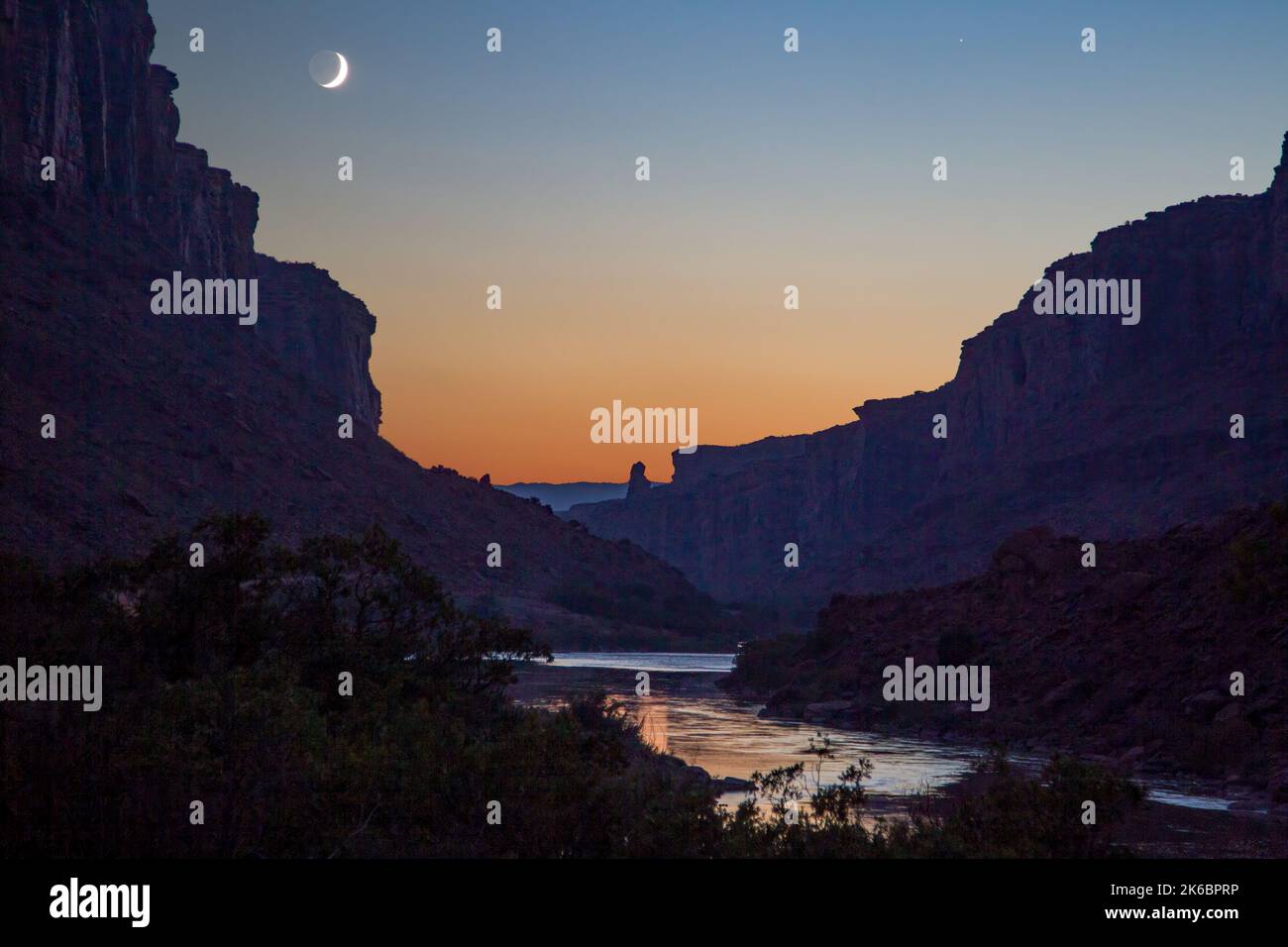 Waxing crescent moon at evening twilight over the Colorado River canyon ...