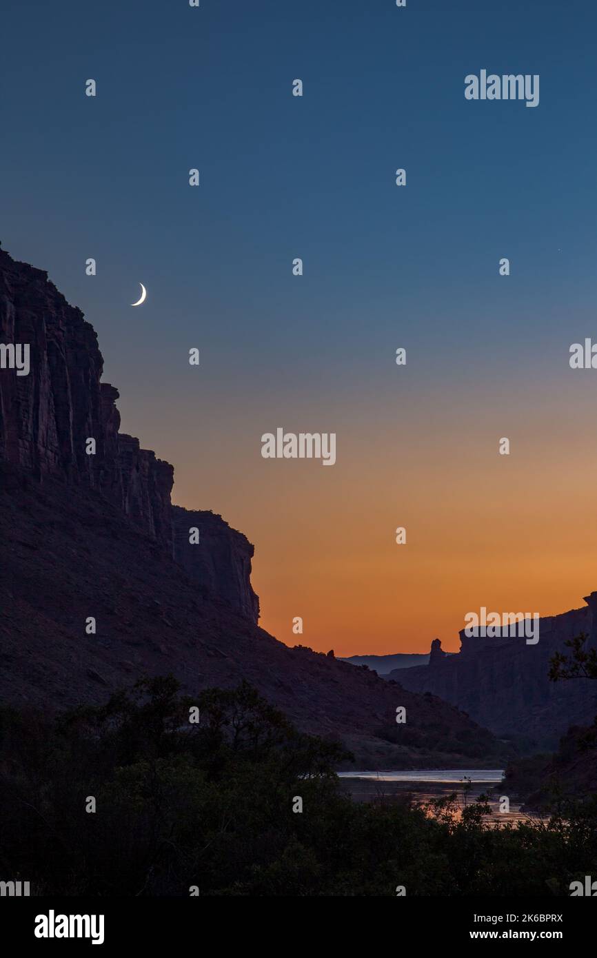 Waxing crescent moon at evening twilight over the Colorado River canyon ...