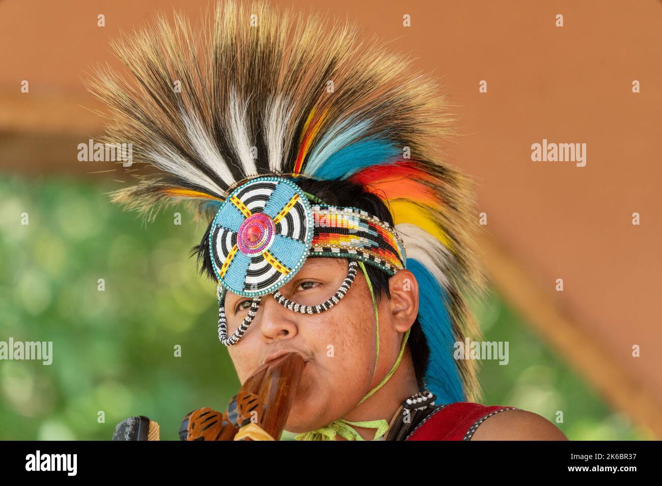 Navajo Native American hoop dancer in regalia playing a double flute at ...