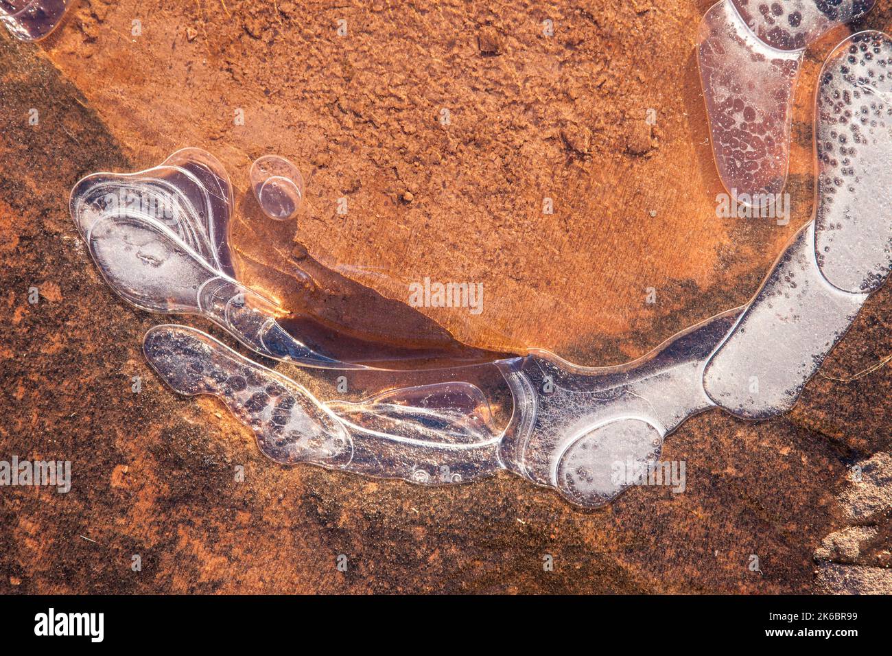 Frozen patterns in ice on sandstone in winter at Arches National Park ...