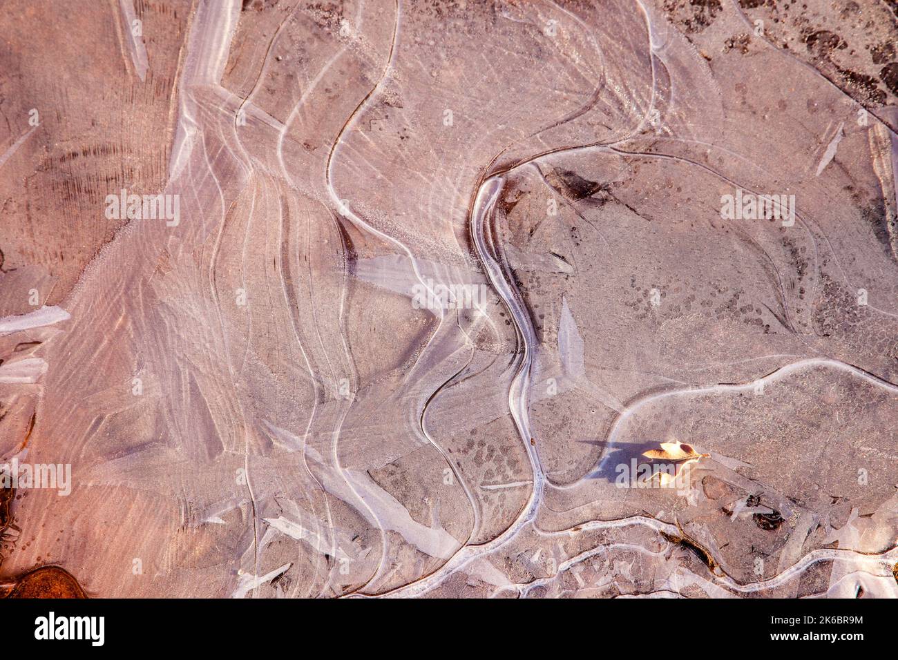 Frozen patterns in ice on sandstone in winter at Arches National Park ...