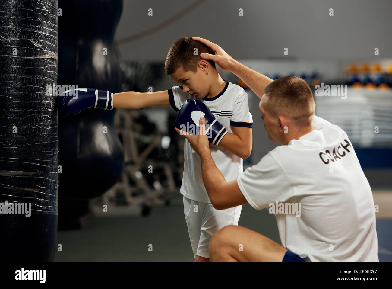 Training in boxing techniques. Junior male boxer practicing with ...