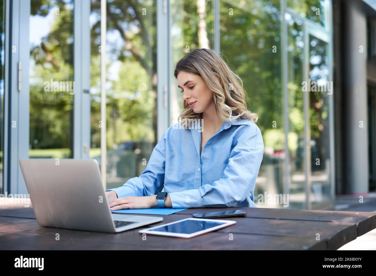 Portrait of beautiful young woman working on fresh air outside ...