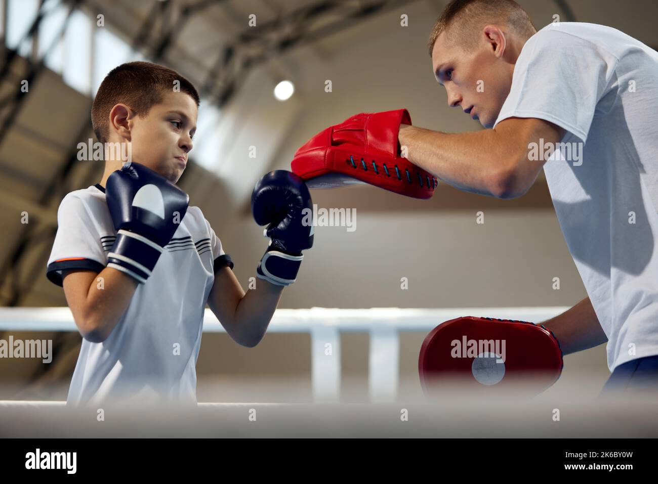 Junior athlete, male boxer training with personal coach at sports gym ...