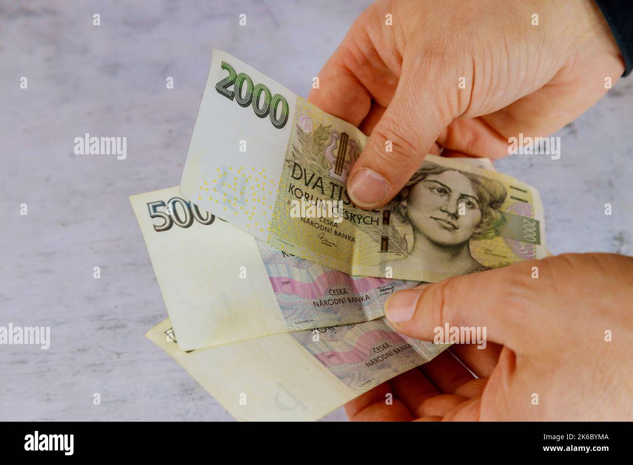 There is man standing behind banknote of Czech Republic holding and ...