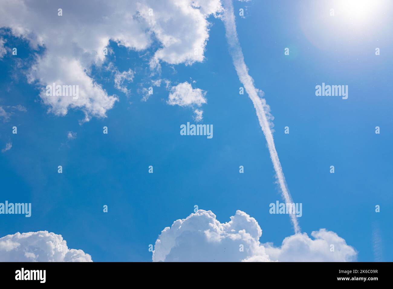 Engine exhaust contrails in the blue cloudy sky Stock Photo - Alamy