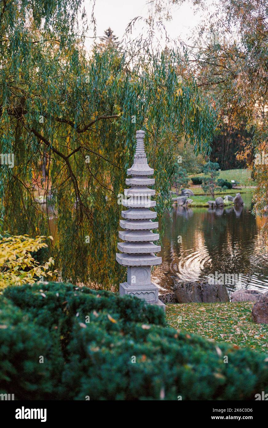 A vertical of an authentic Japanese tower statue in a garden with a ...