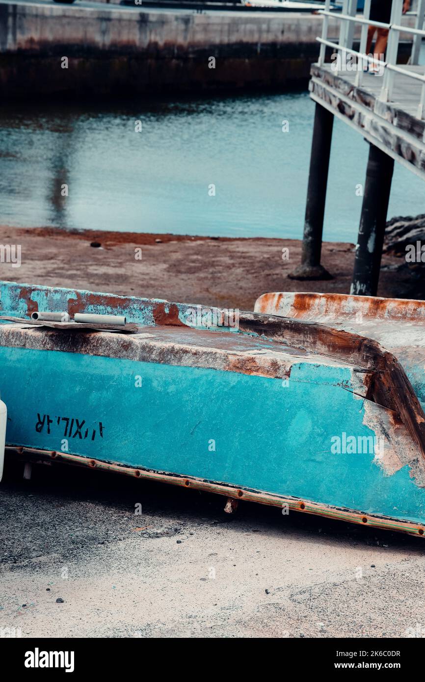 A vertical of a blue rusty boat abandoned in the coast Stock Photo - Alamy