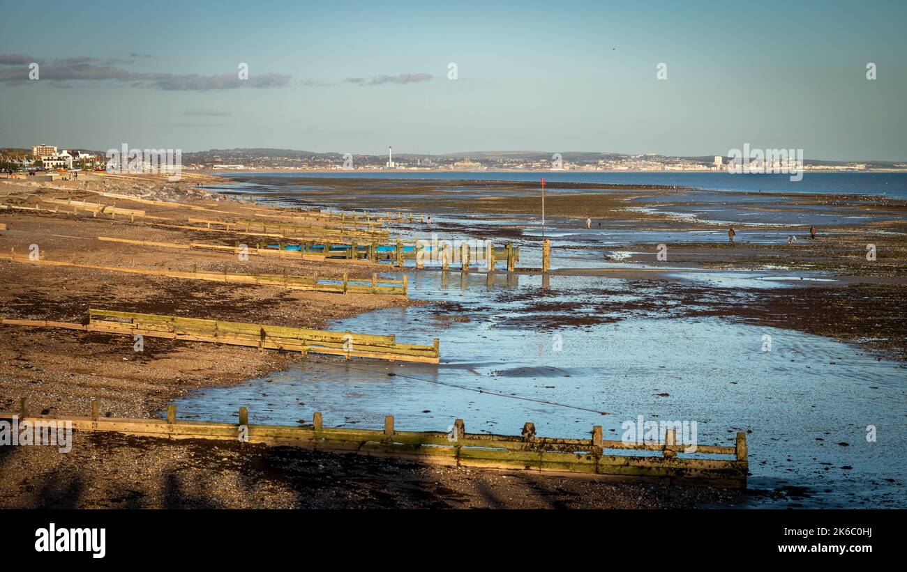 A view eastwards at low tide down Worthing beach in West Sussex, UK ...