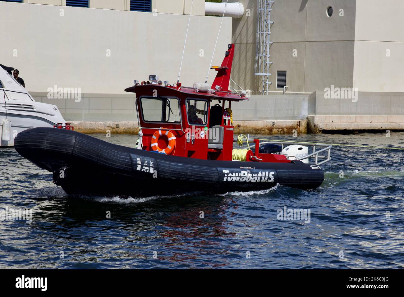 A tugboat in waters with a building in the background on the ...