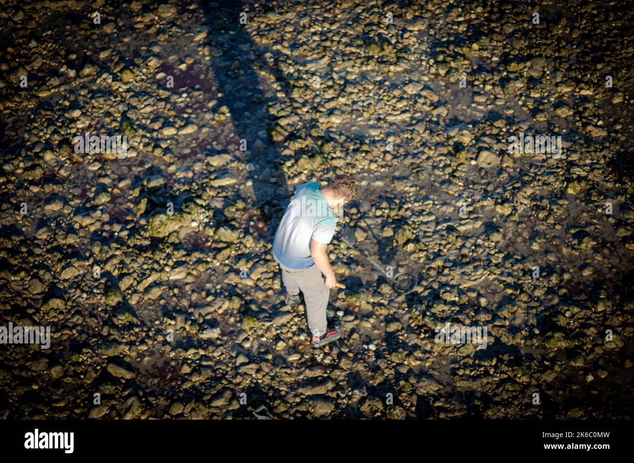 A male metal detectorist searches for long lost items in the late ...