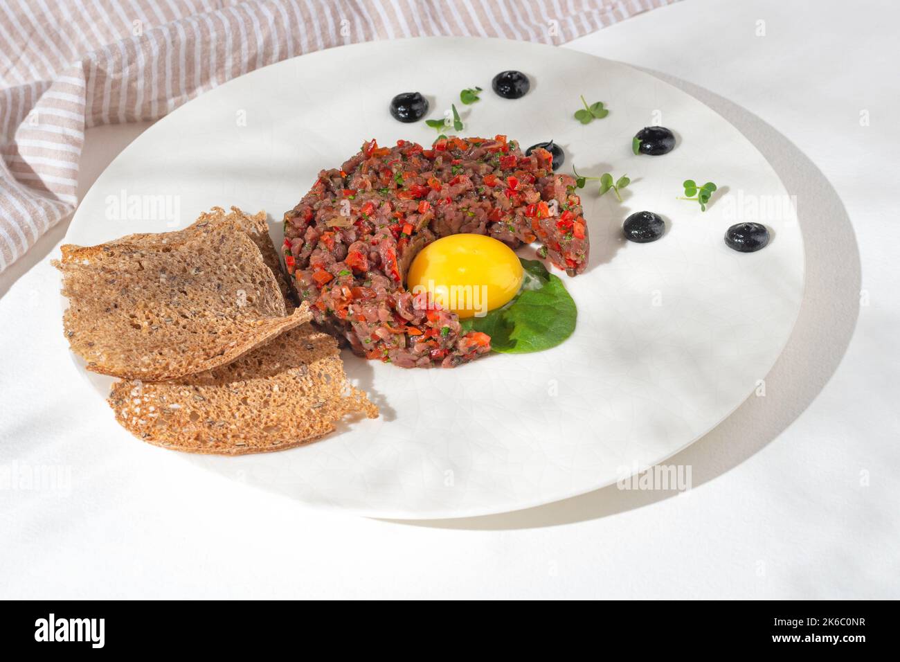 beef tartar with capers and small toasts on white background for ...