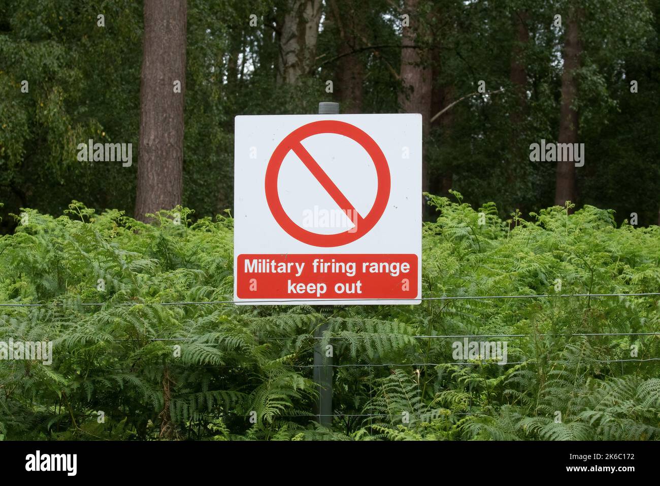 A "Keep Out" warning sign for a Military firing range against a forest ...