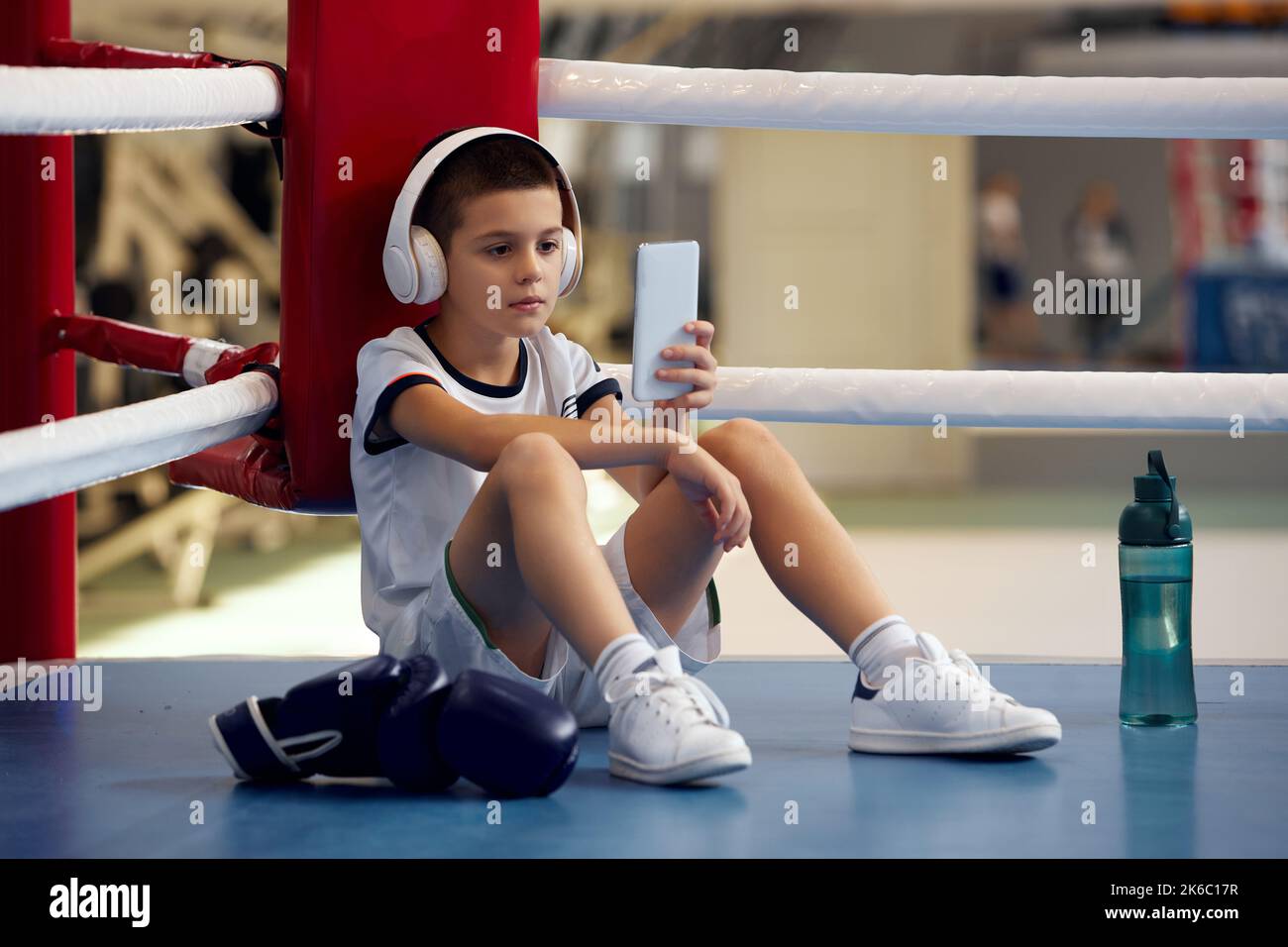 Scrolling social media feed after training. Life portrait of little boy ...