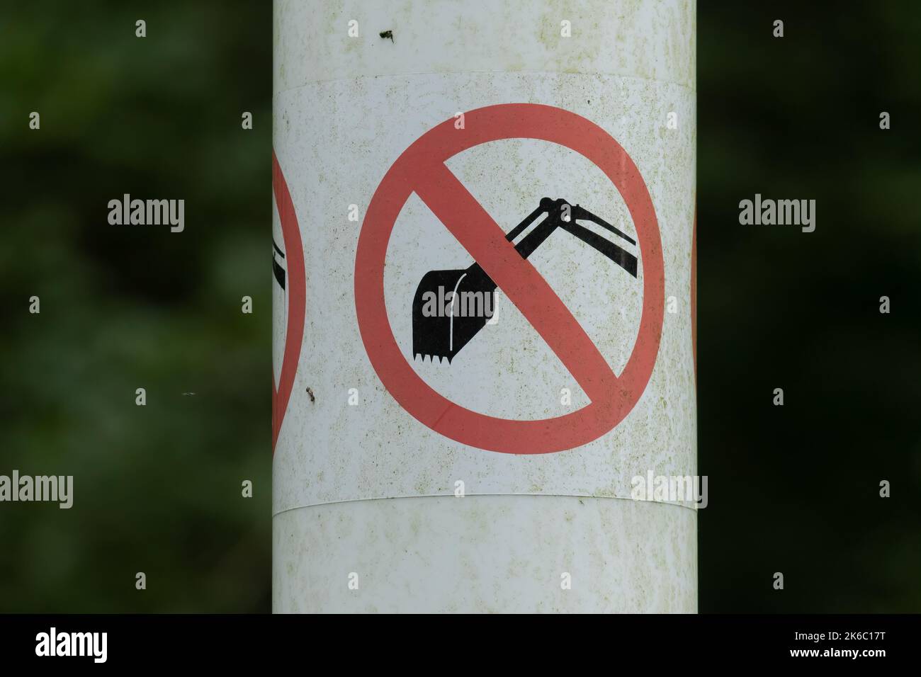 A warning circular advisory sign warning not to use a mechanical digger ...