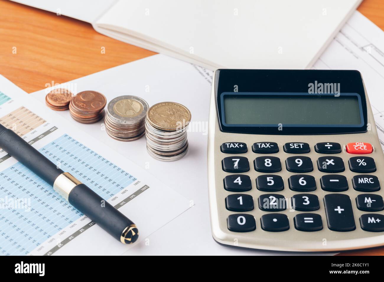 pile of money coins with graph paper on wood table, concept in account ...