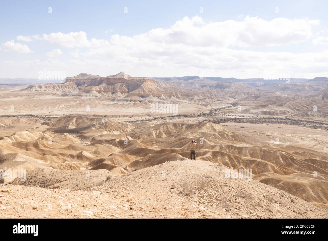 hiker photographing a desert scenery, Zin valley, Negev desert, Israel ...