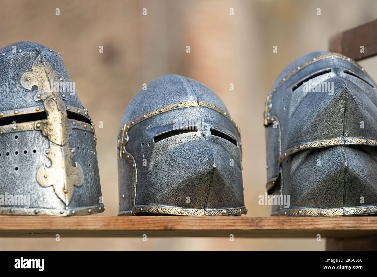 three medieval helmets over a wooden board Stock Photo - Alamy