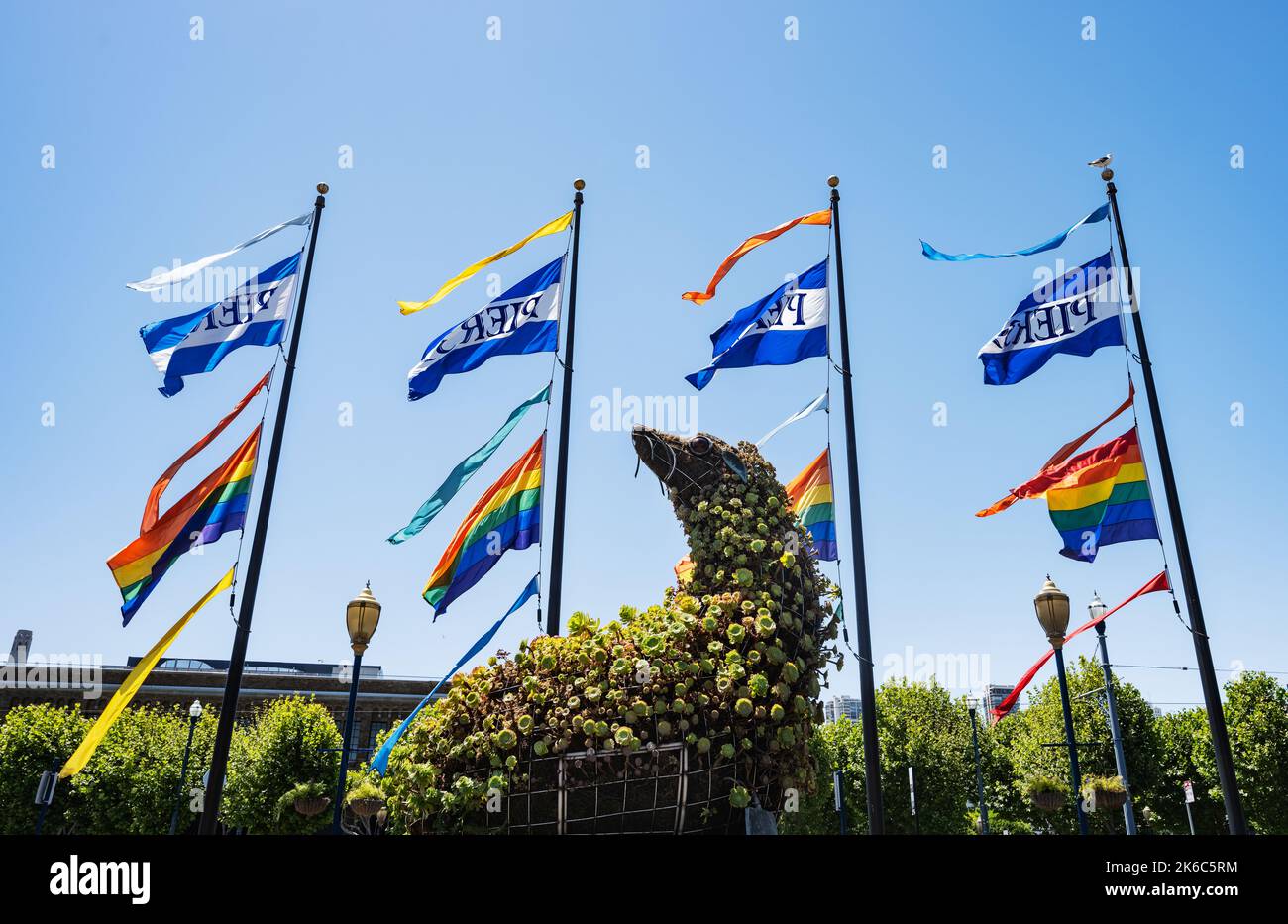 Seal sculpture covered with plant life with flags in the background on ...