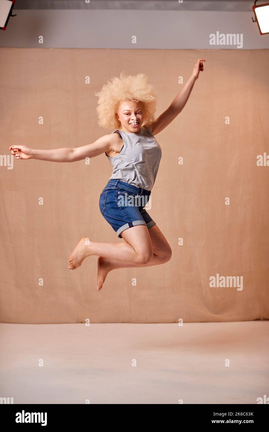 Studio Portrait Shot Of Body Positive Albino Woman Jumping In The Air ...