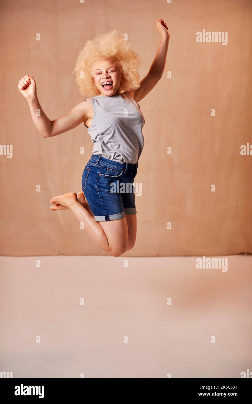 Studio Portrait Shot Of Body Positive Albino Woman Jumping In The Air ...