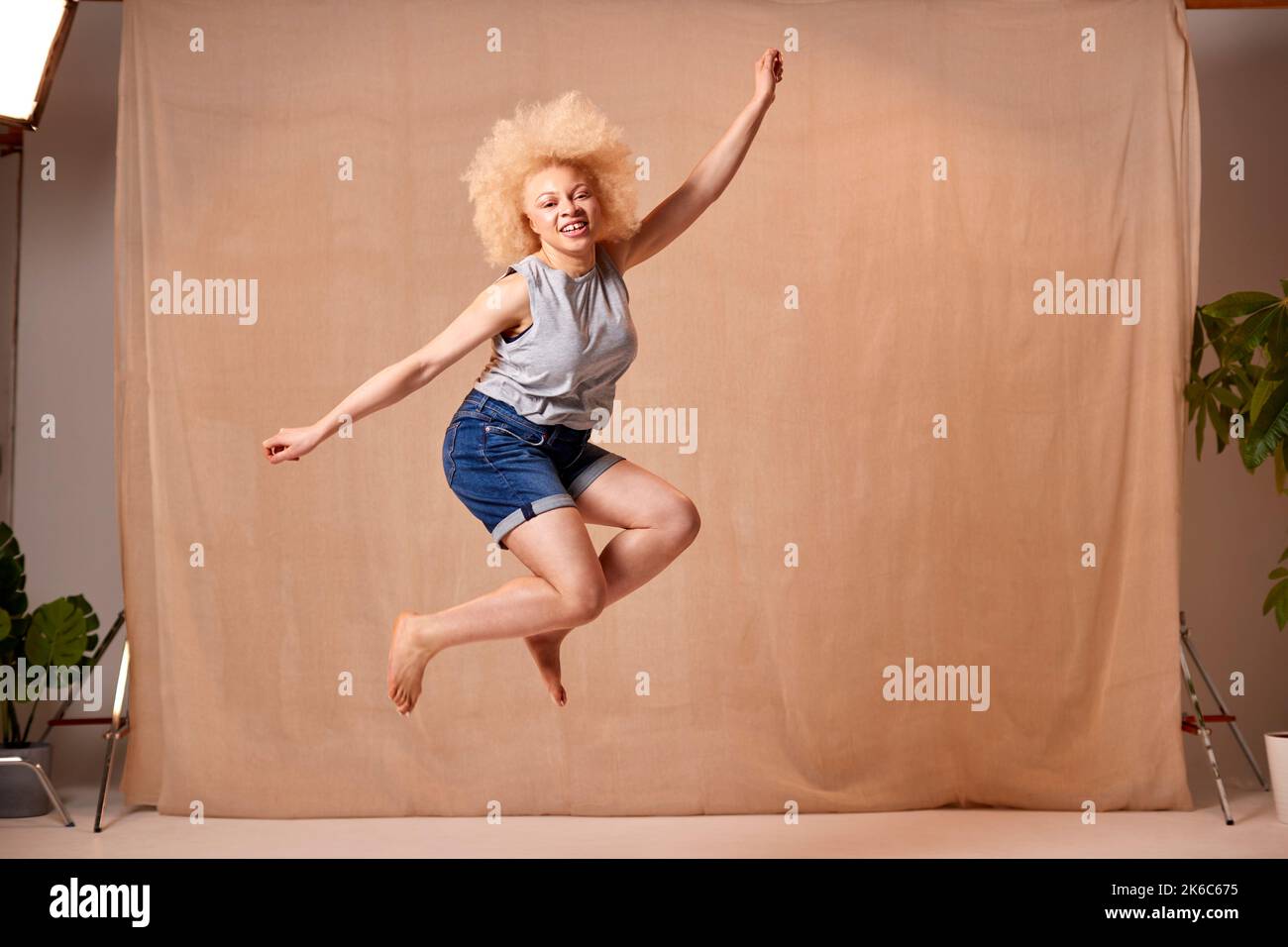 Studio Portrait Shot Of Body Positive Albino Woman Jumping In The Air ...