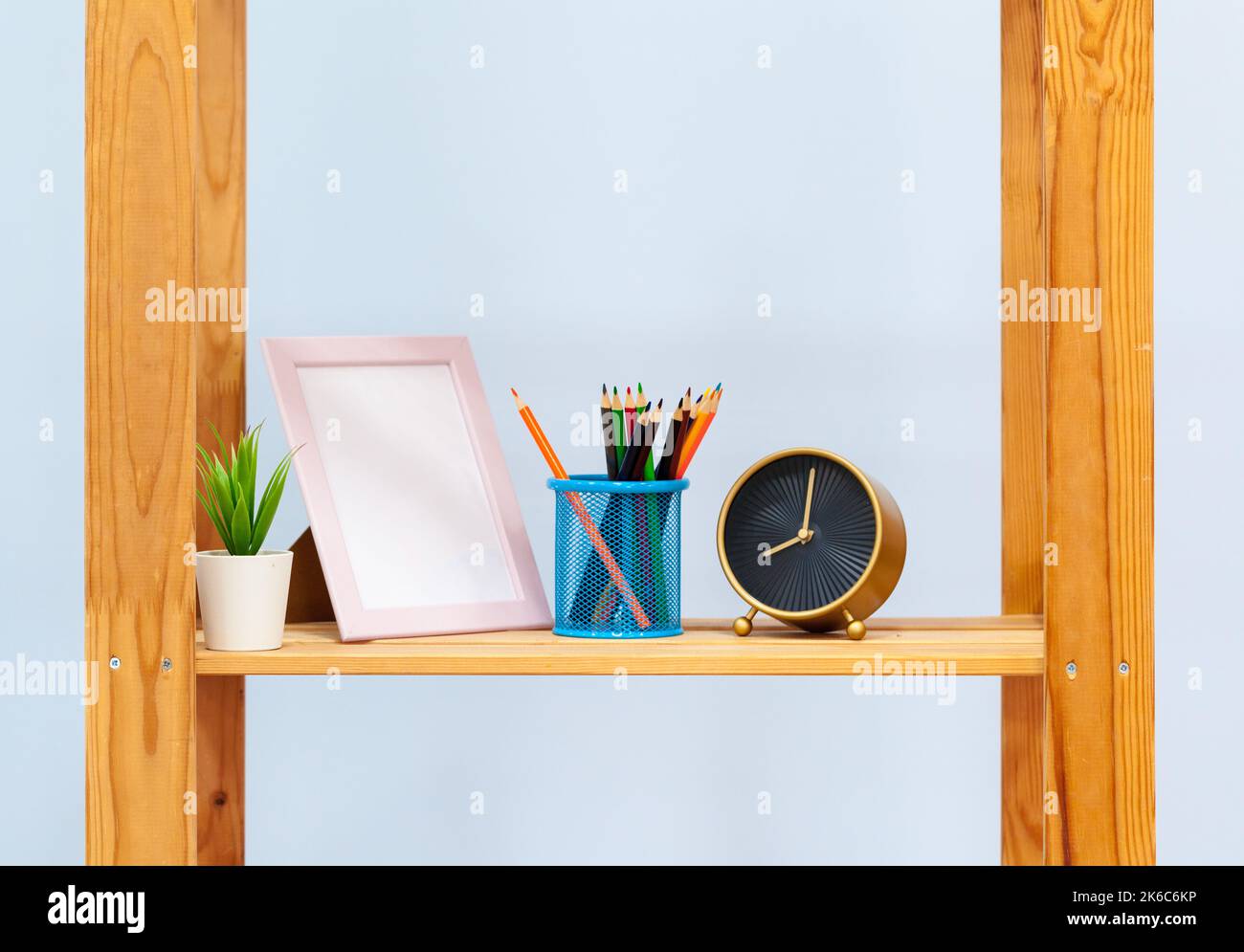Wooden shelf with alarm clock and objects against blue background Stock ...