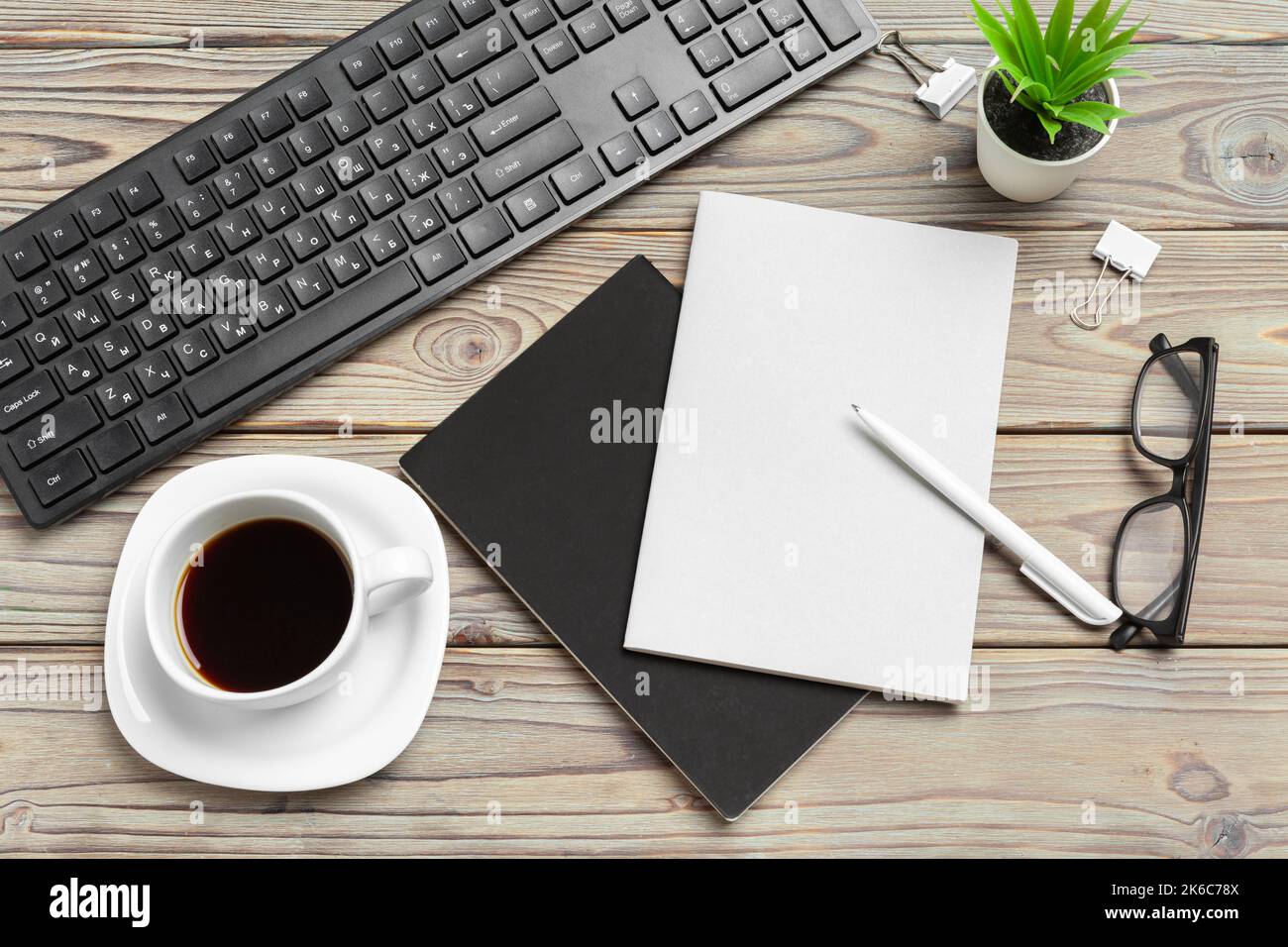 Top view of wooden desktop with glasses and stationery items close up ...