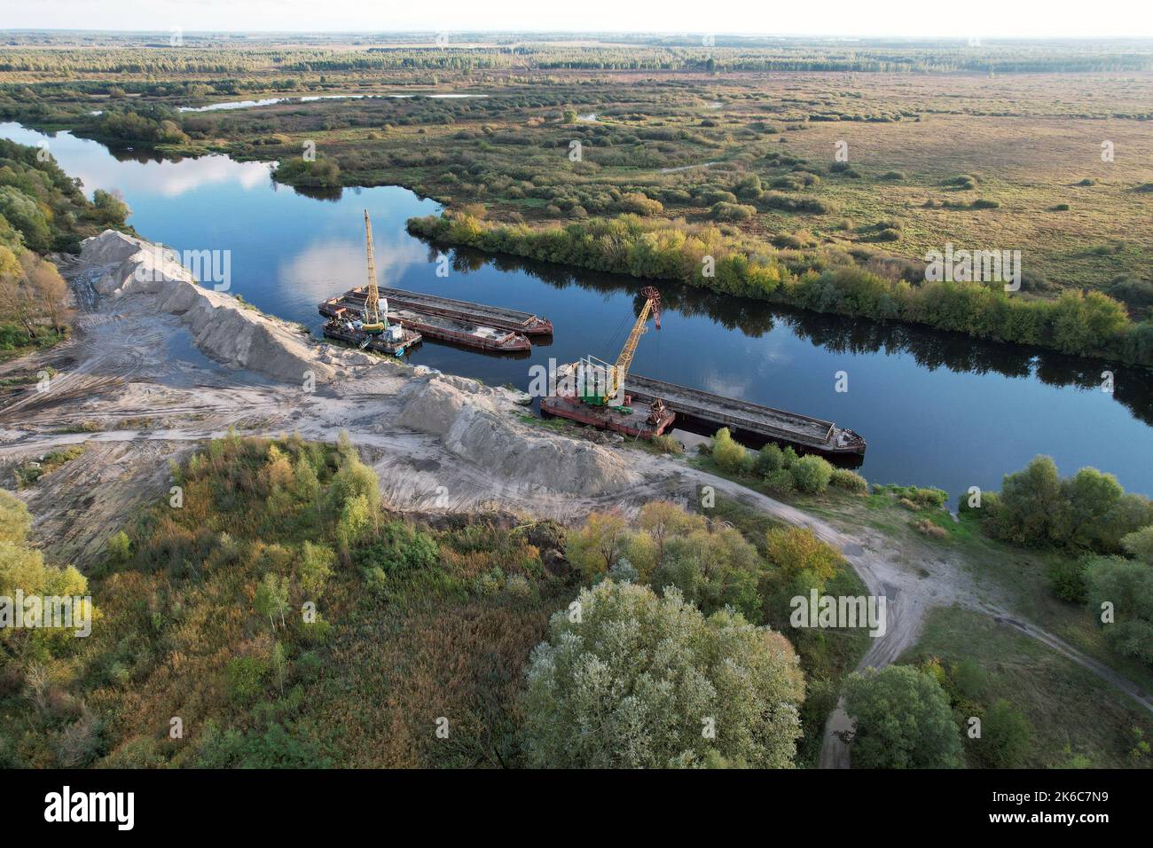 Large floating cranes unload bulk materials on the banks of the river ...